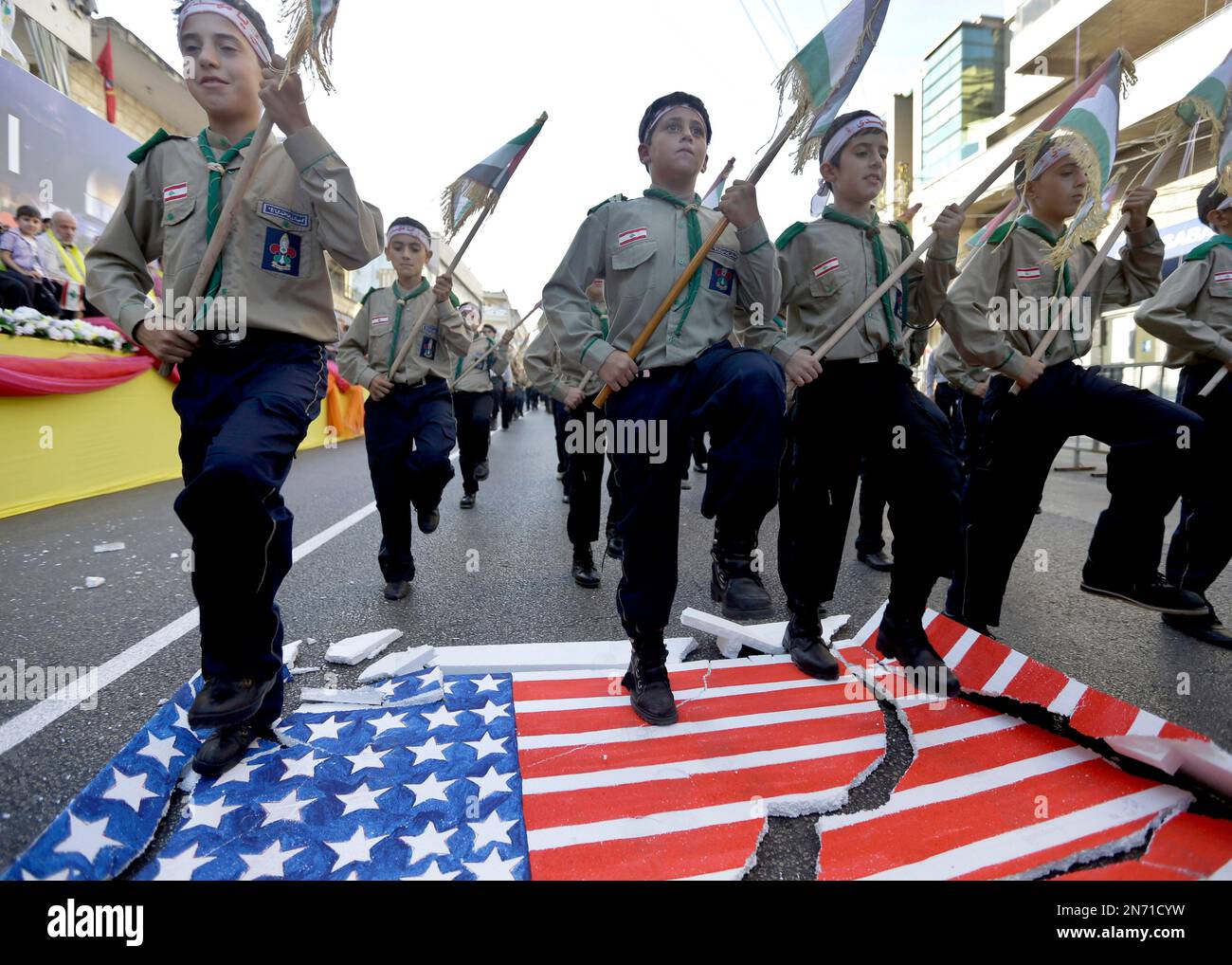 Hezbollah al-Mahdi scouts march over a representation of a U.S. flag as ...