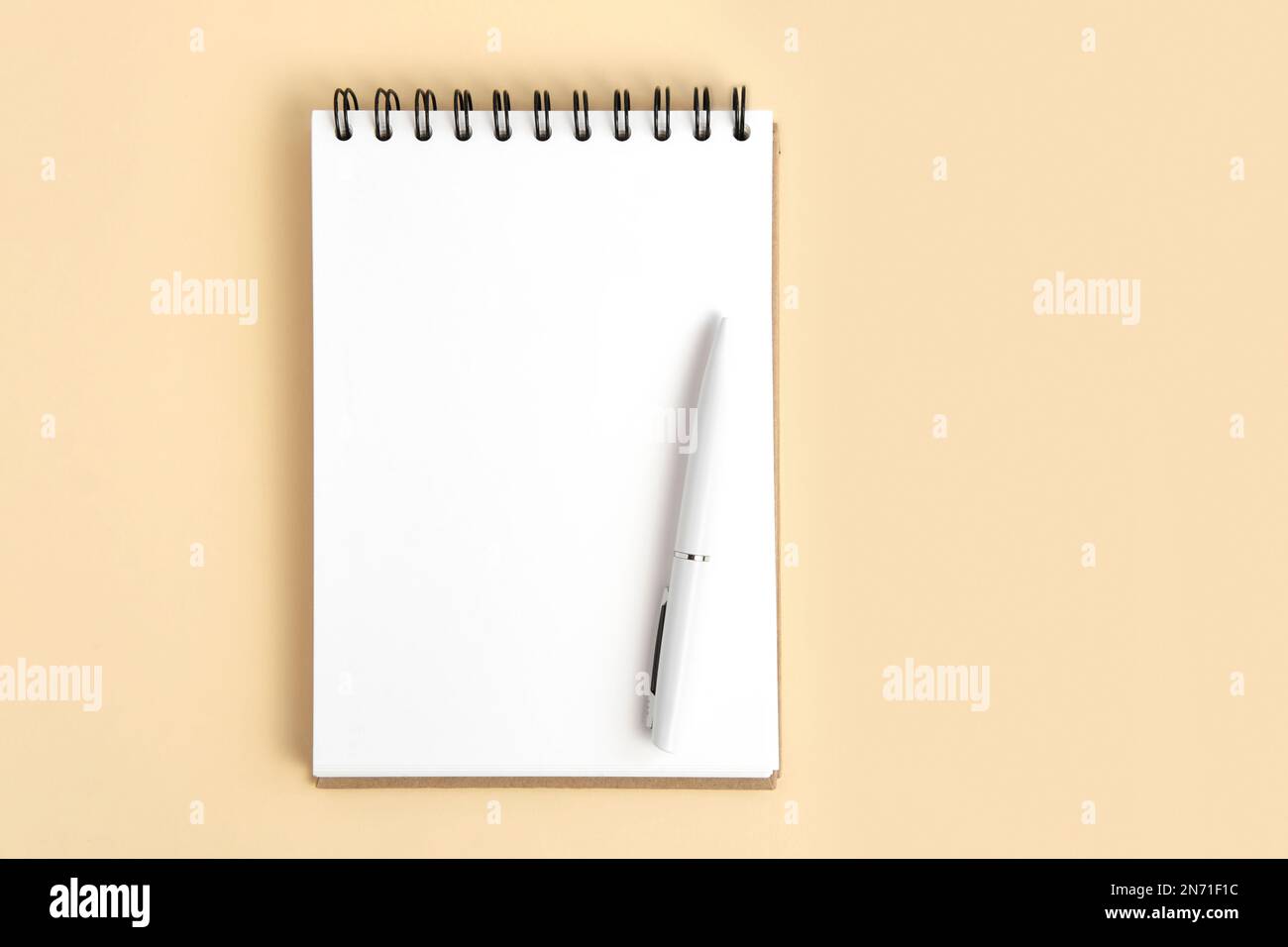 Notebook and pen. Spiral notepad on neutral beige color studio ...