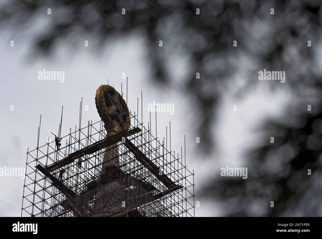 Workers labor on the scaffolding built around a People's Liberation ...