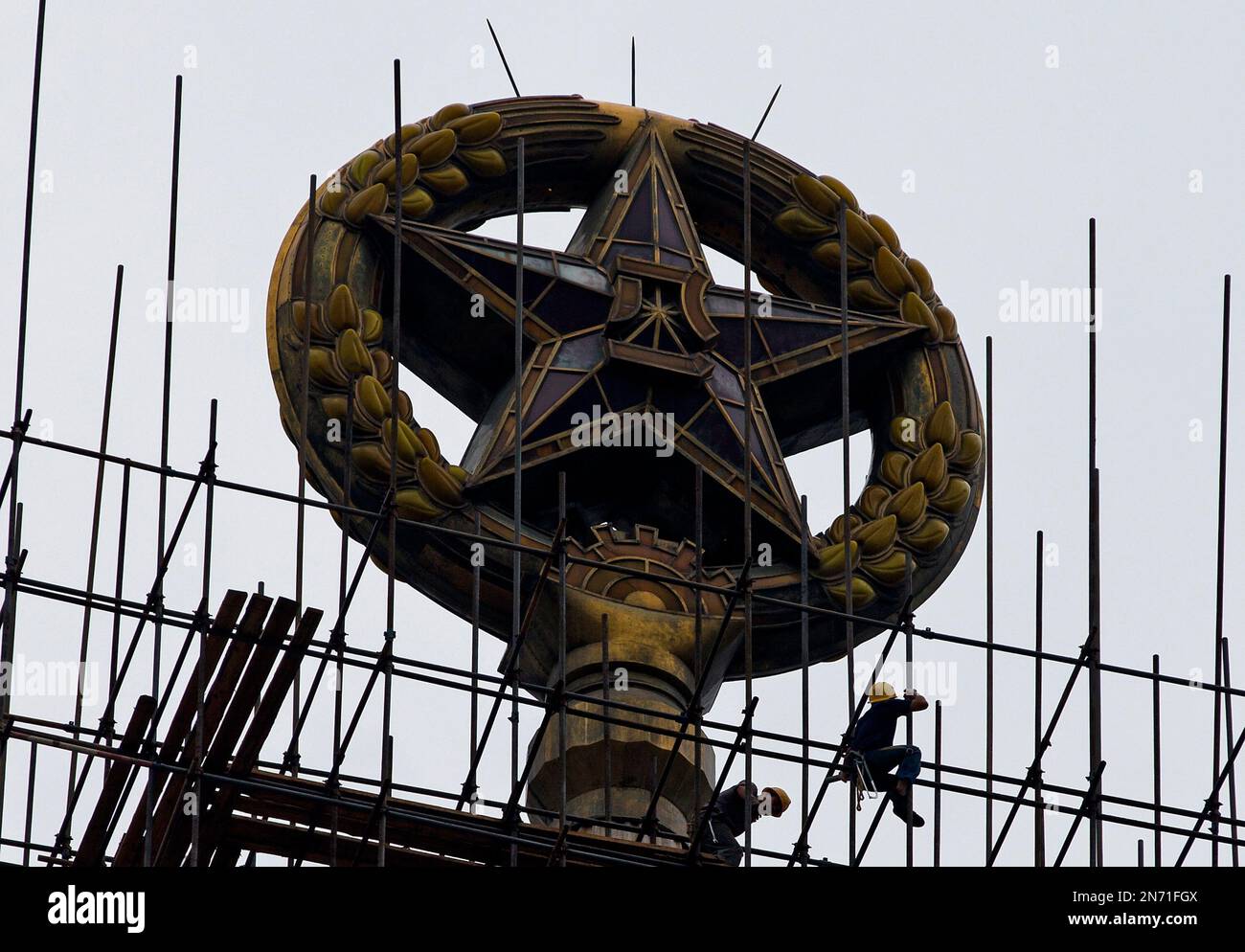 Workers labor on the scaffolding built around a People's Liberation ...