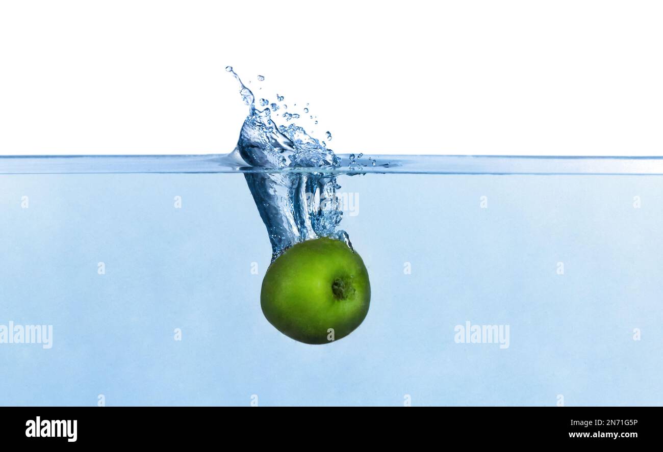 Apple falling down into clear water against white background Stock ...