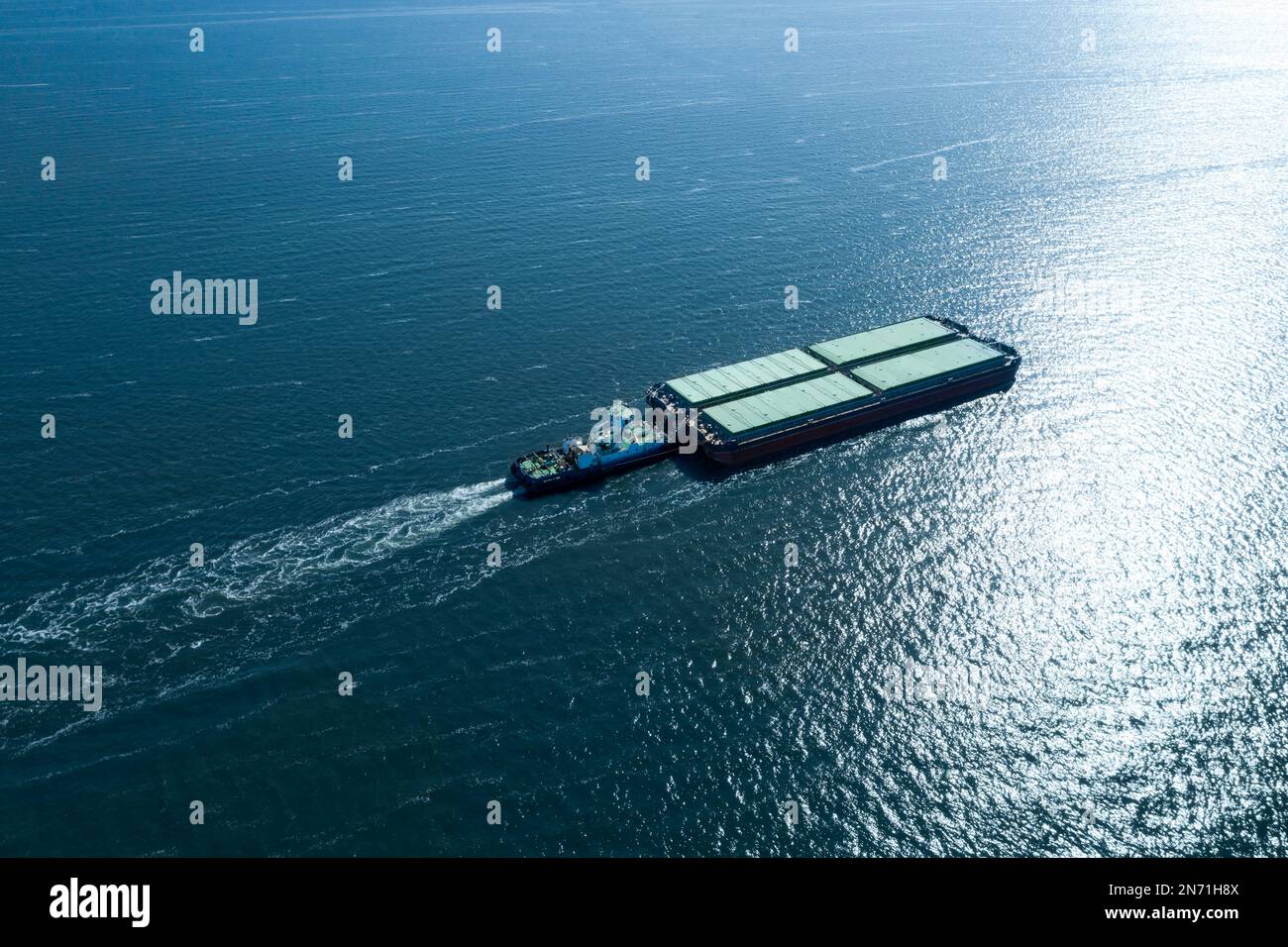 Tugboat pulling barge with cargo by water, aerial view Stock Photo - Alamy