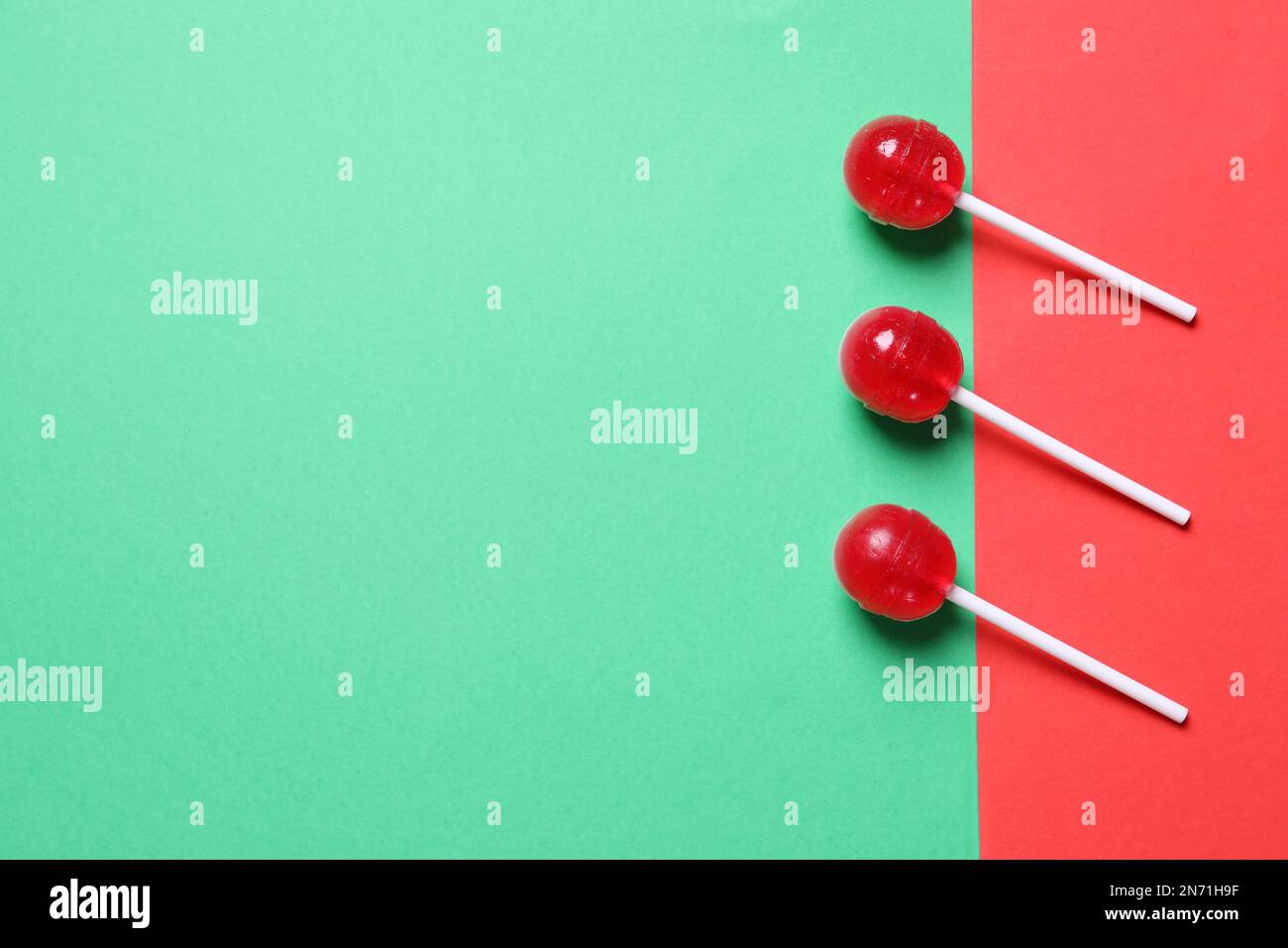 Three red lollipops on color background, flat lay. Space for text Stock ...