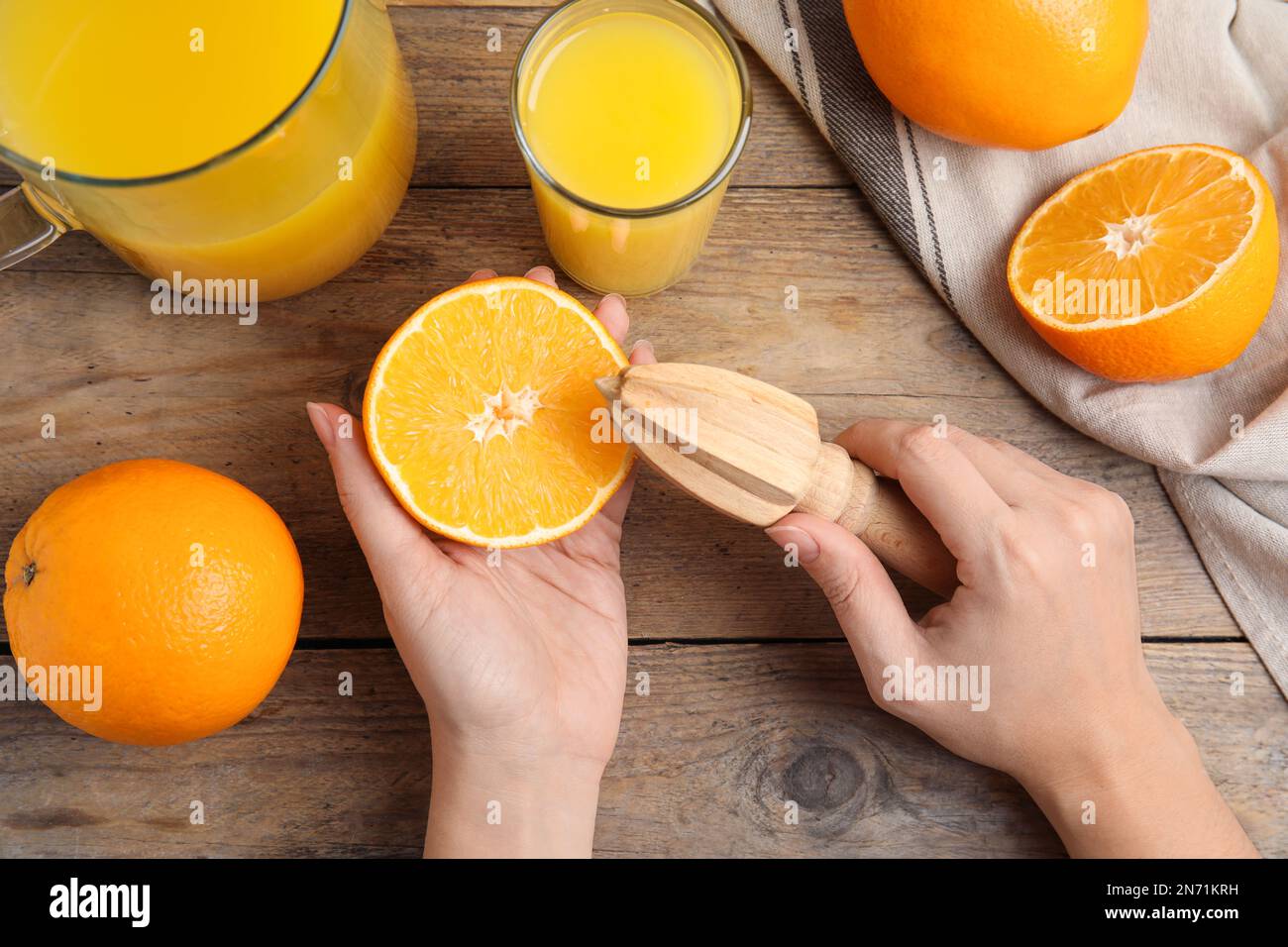 Woman squeezing orange juice at wooden table, top view Stock Photo - Alamy