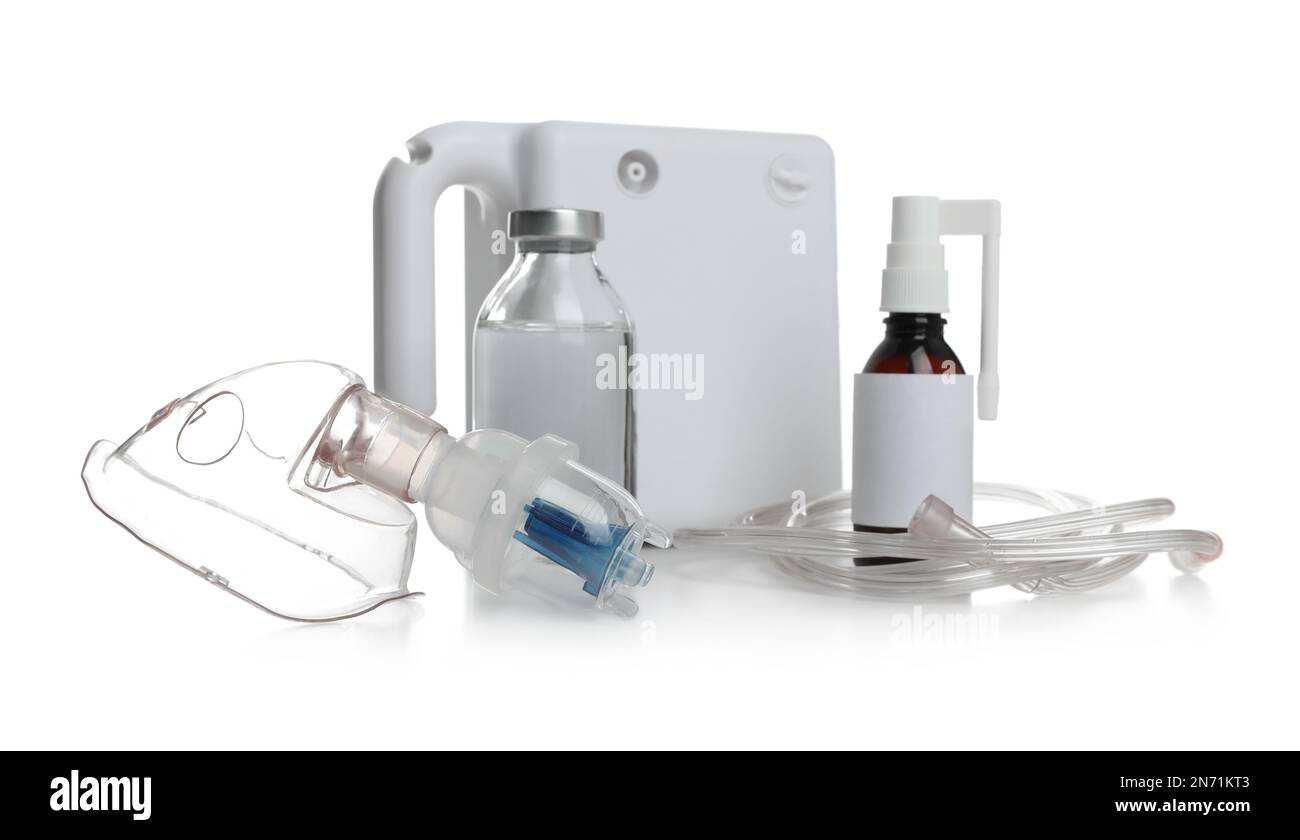 Modern nebulizer with face mask and medications on white background ...