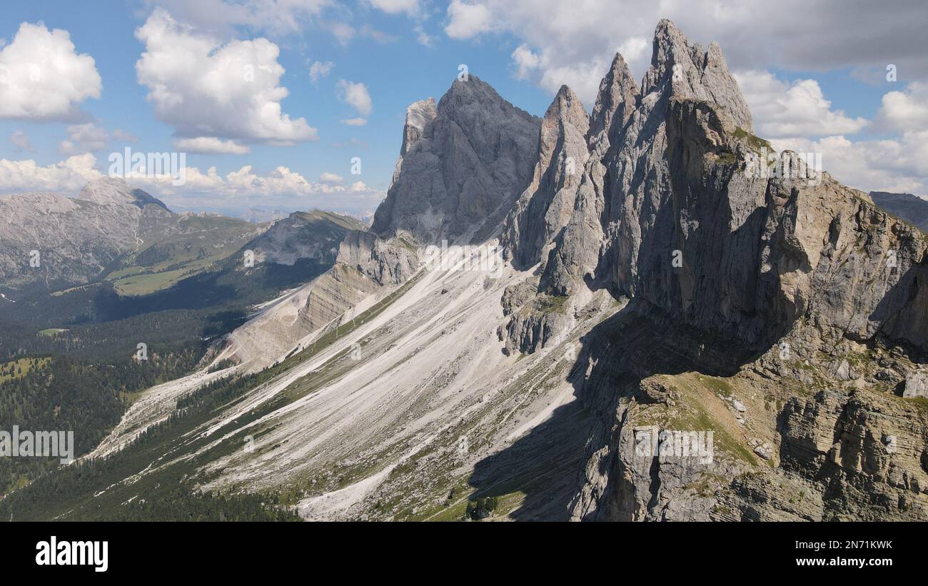 An aerial shot of Seceda Mountain with floating clouds above in the ...