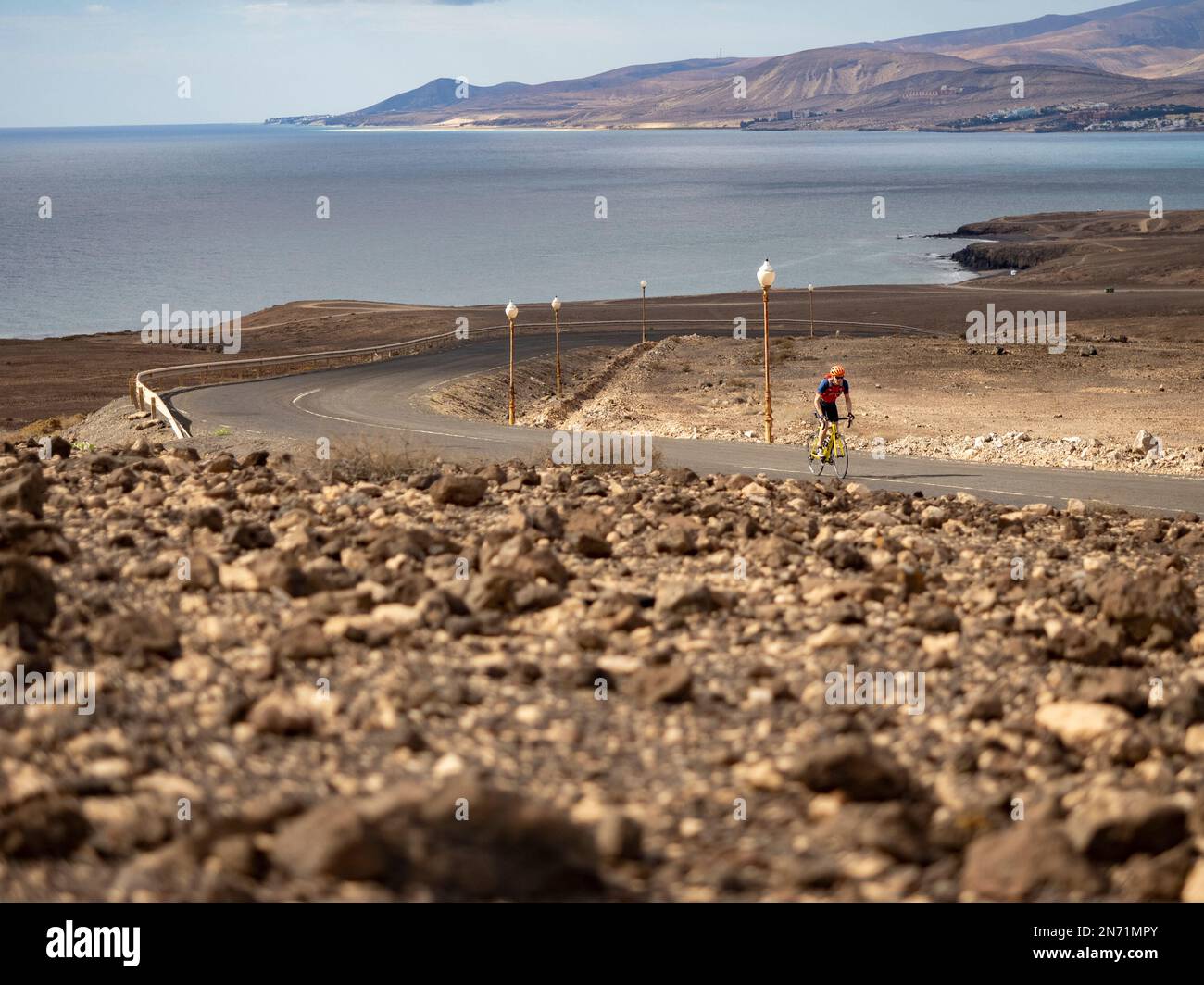 Road cyclist on coastal road overlooking the beaches of Costa Calma in ...