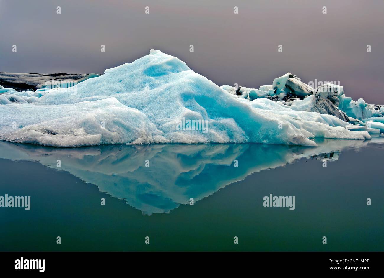 Reflections of crystal blue and white icerbergs in black dark smooth ...