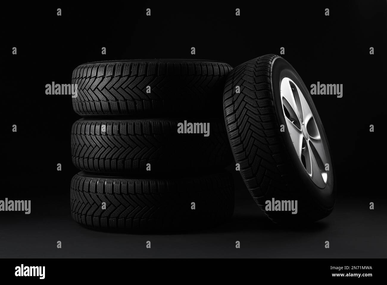 Set of wheels with winter tires on black background Stock Photo - Alamy