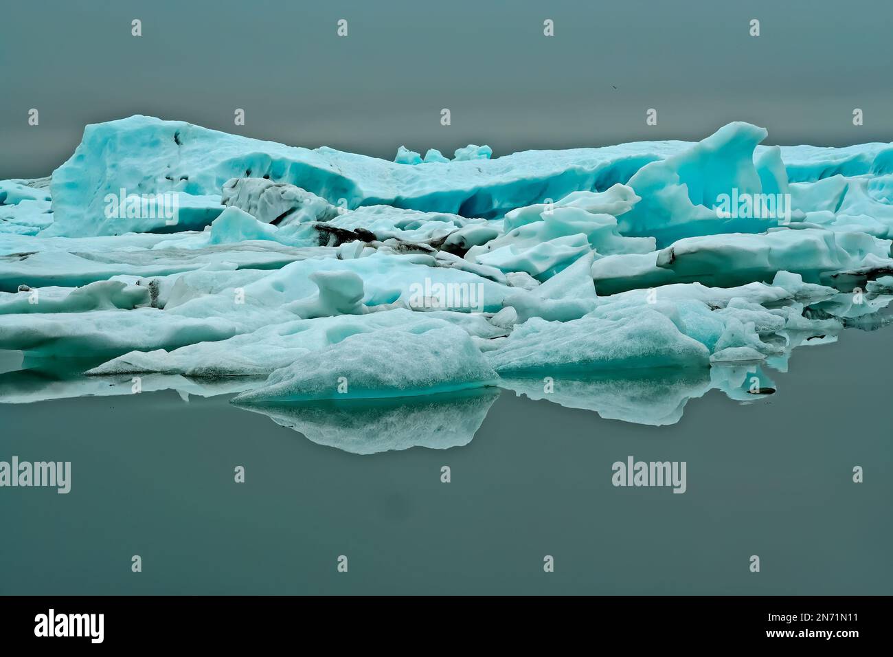 Reflections of crystal blue and white ice floes in black dark glassy ...