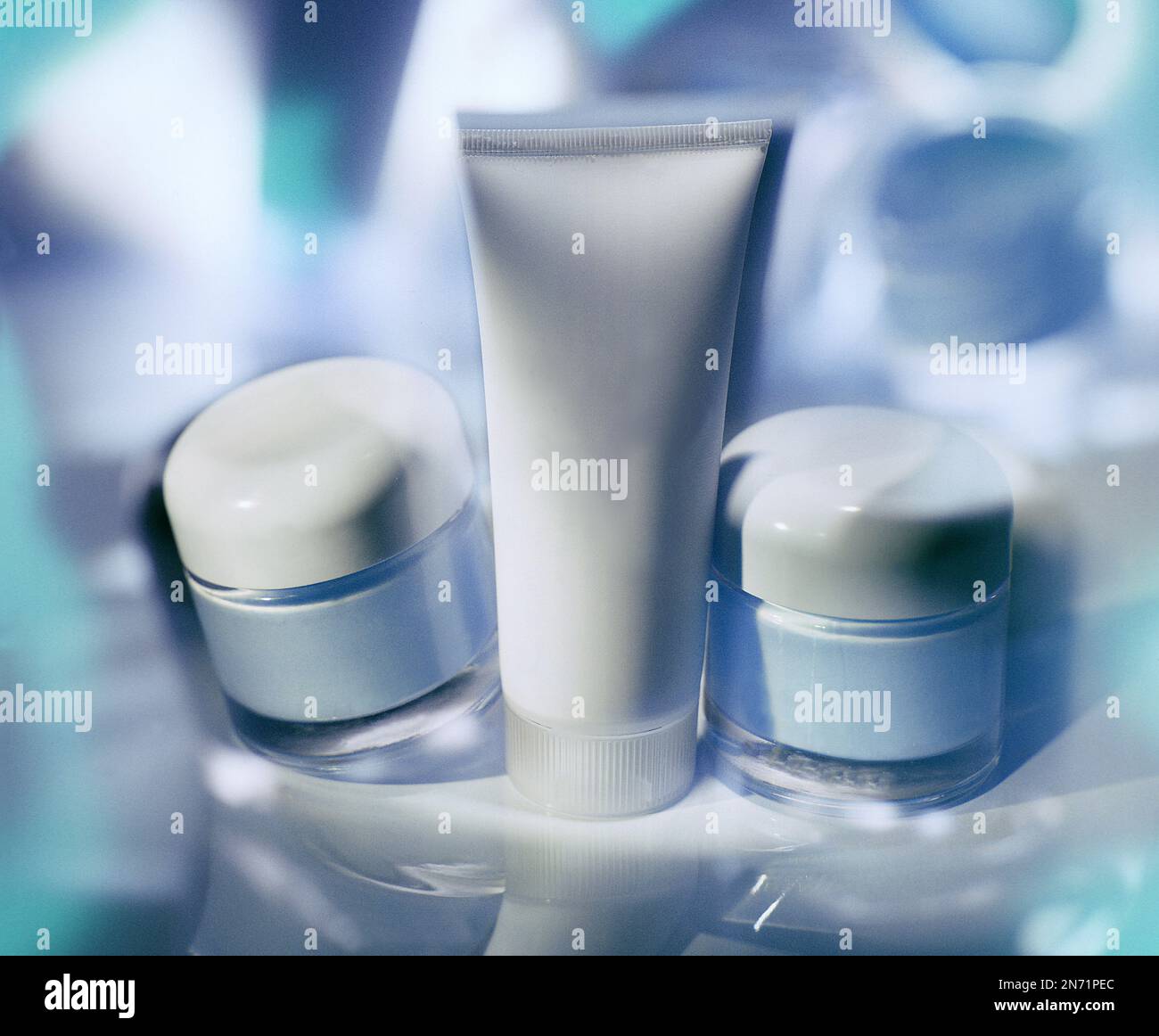 Group of private label cosmetic tubes and jars in reflective concept ...