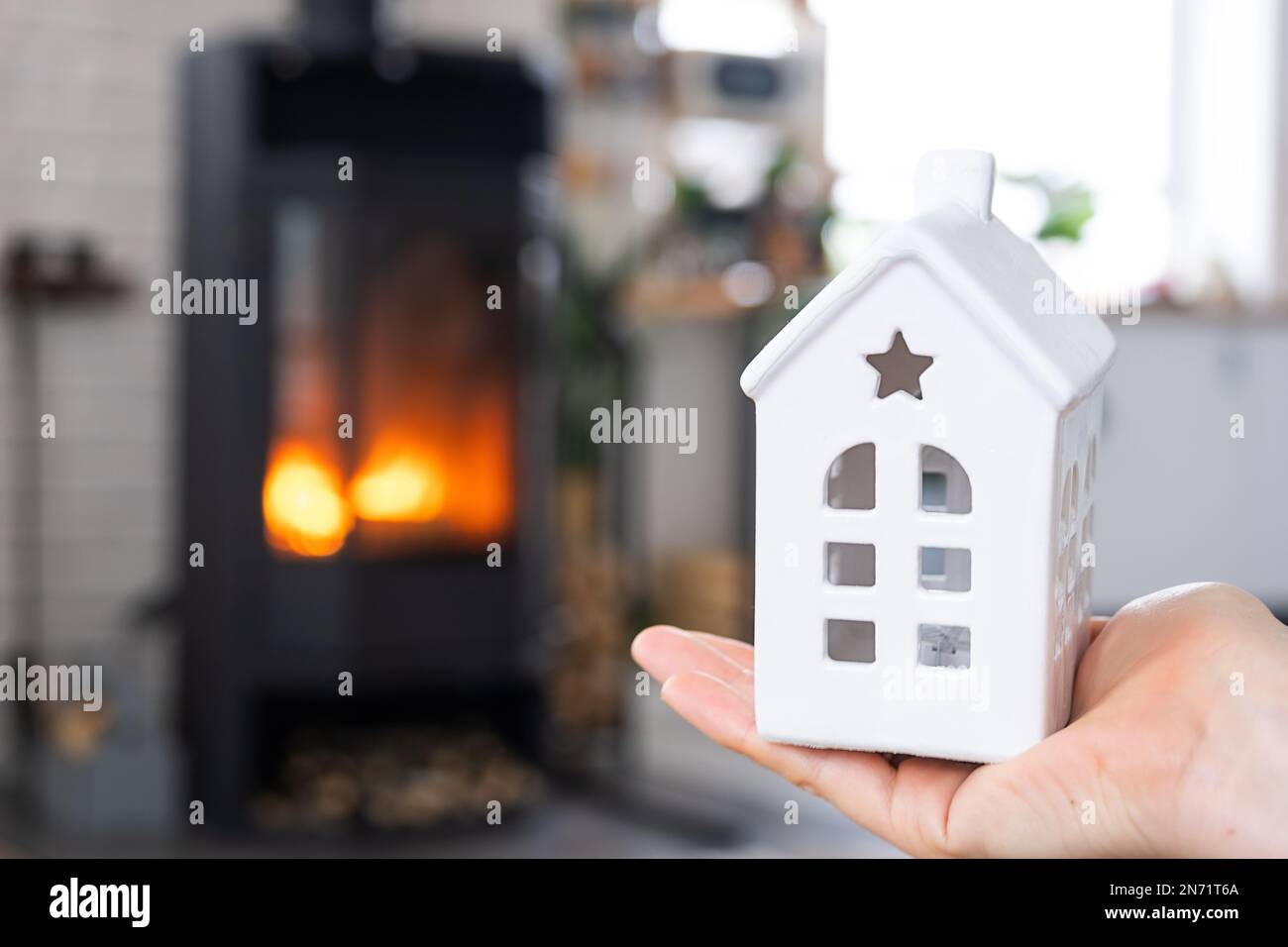 Key to house with keychain in hand owner against of fireplace stove ...
