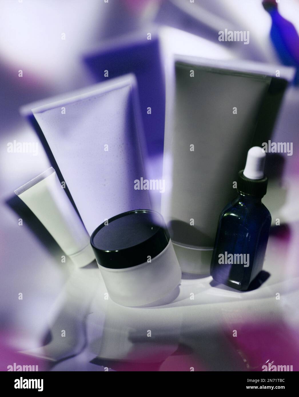 Group of private label cosmetic tubes and jars in reflective concept ...