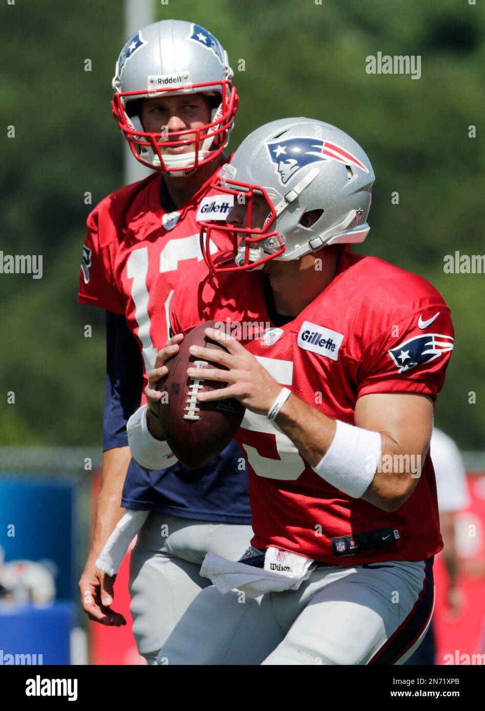 New England Patriots quarterback Tom Brady, left, watches as teammate ...