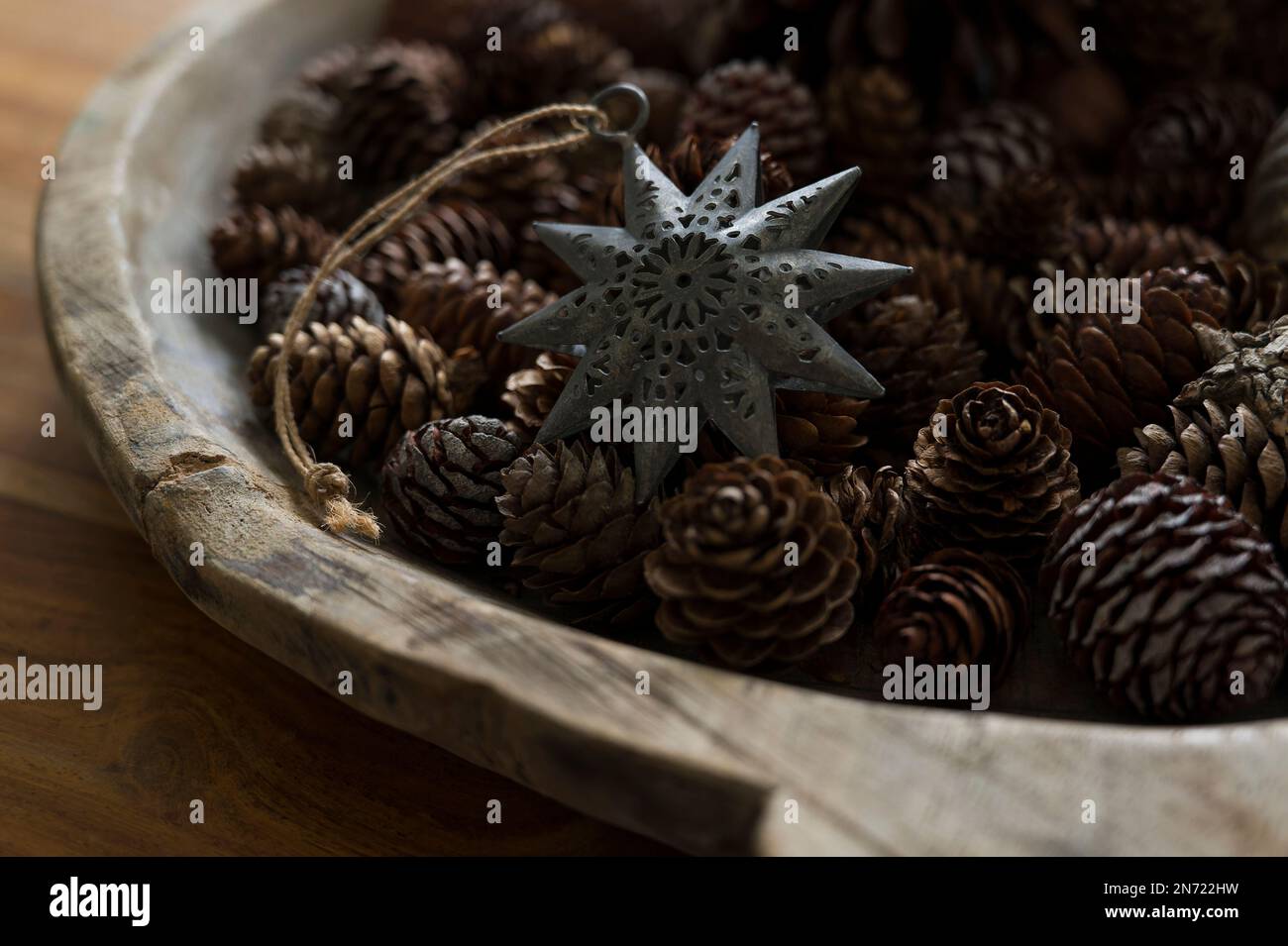Star and cones from different conifers in an old wooden bowl ...