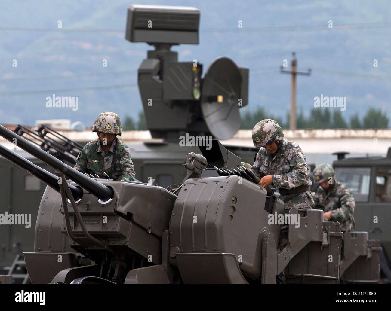 Soldiers load the ammunition to the PG99 twin-barrel 35mm anti-aircraft gun in front of a LLP12A ...