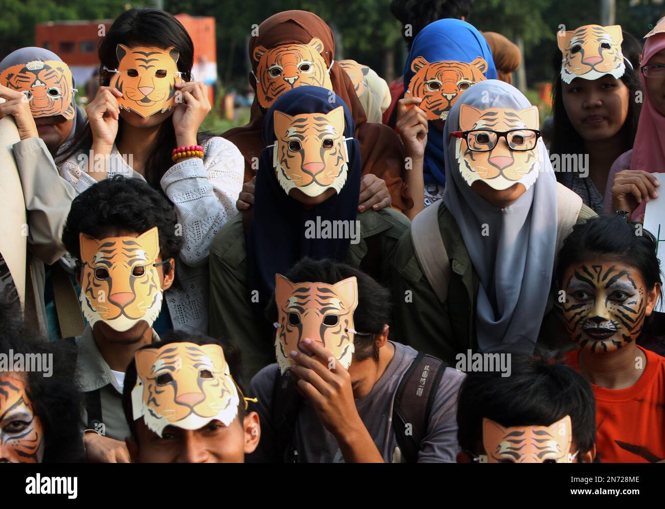 Activists wear tiger masks during a protest against Sumatran tiger ...
