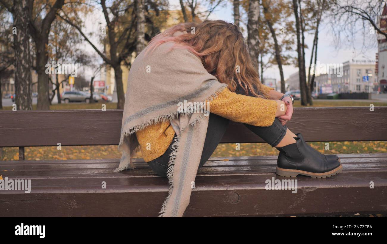 A young girl crying on a park bench in the fall Stock Photo - Alamy