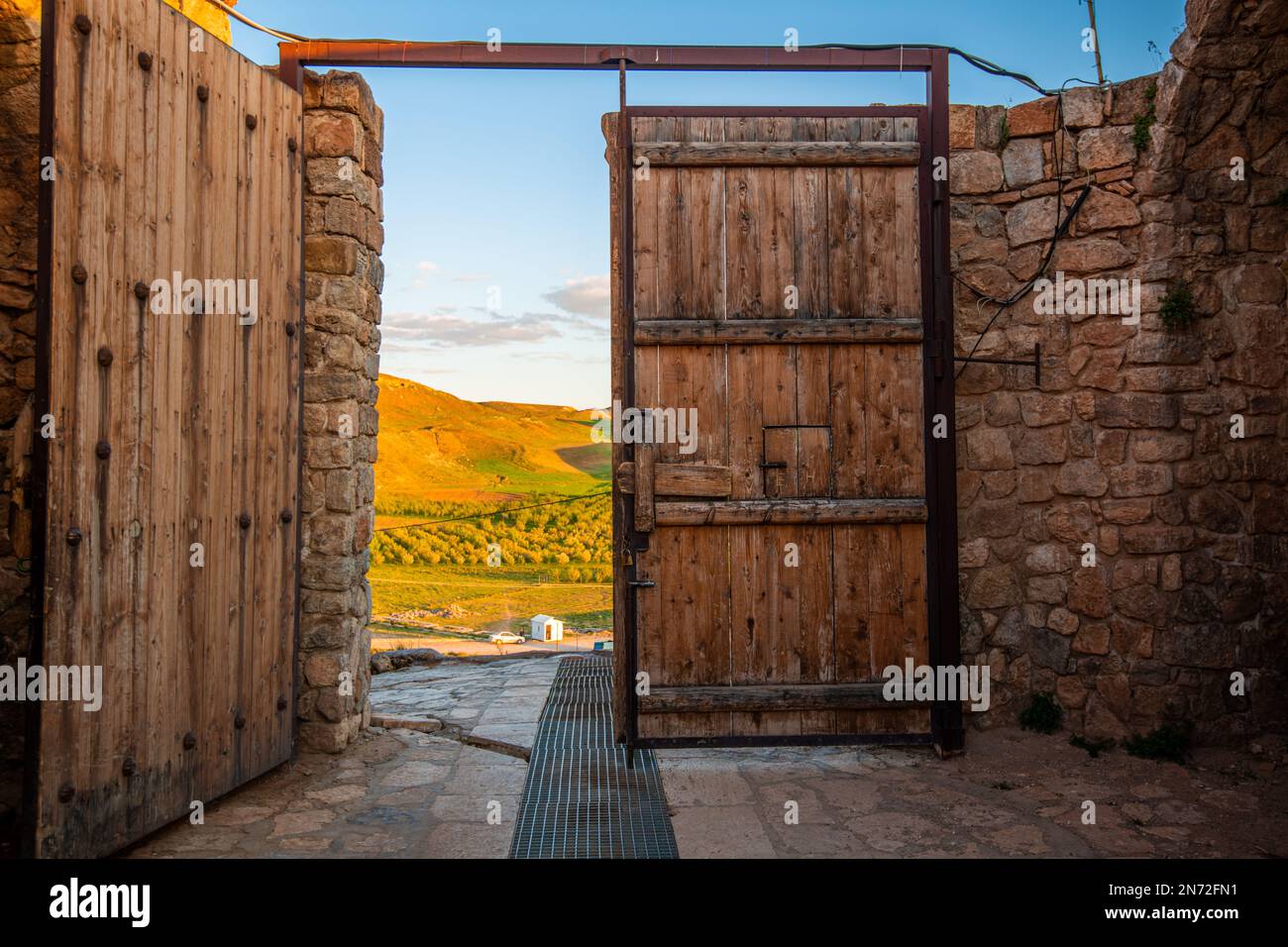 Old stone walls and wooden doors of structures at Takht-e Soleyman in ...