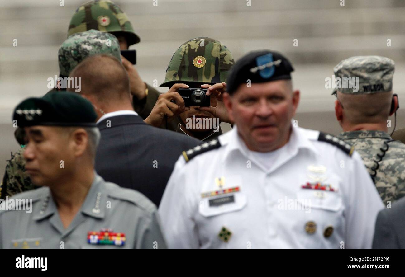 A North Korean soldier, center, takes picture as Gen. James D. Thurman ...