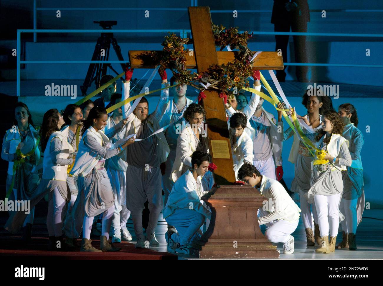 A group places a cross on the stage during the Stations of the Cross ...