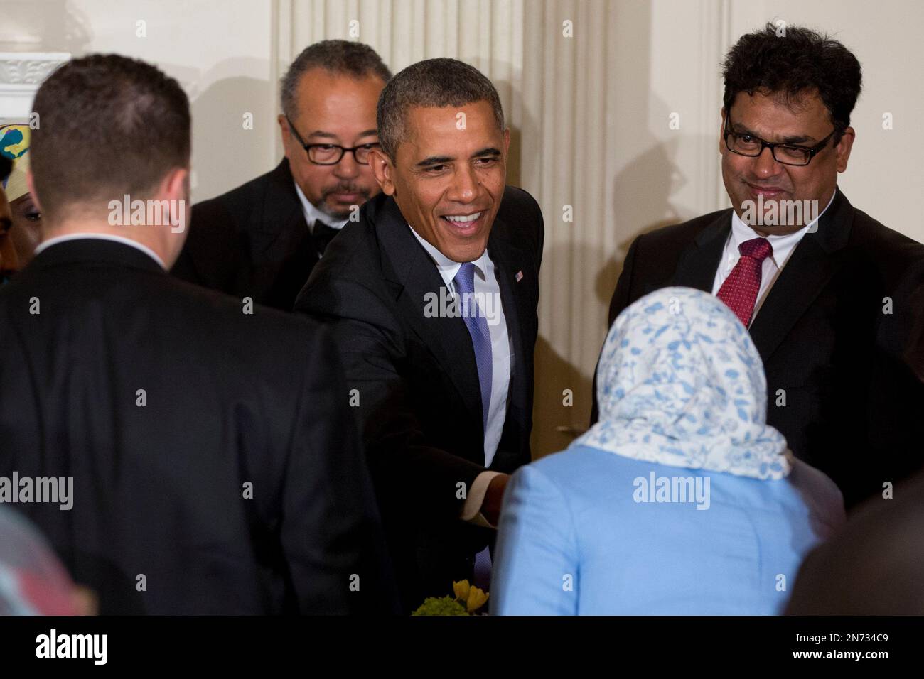 President Barack Obama greets people at his table as he hosts an Iftar ...