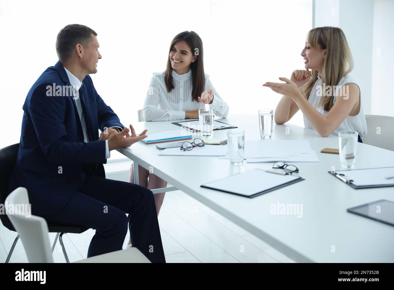 Office employees talking at table during meeting Stock Photo - Alamy