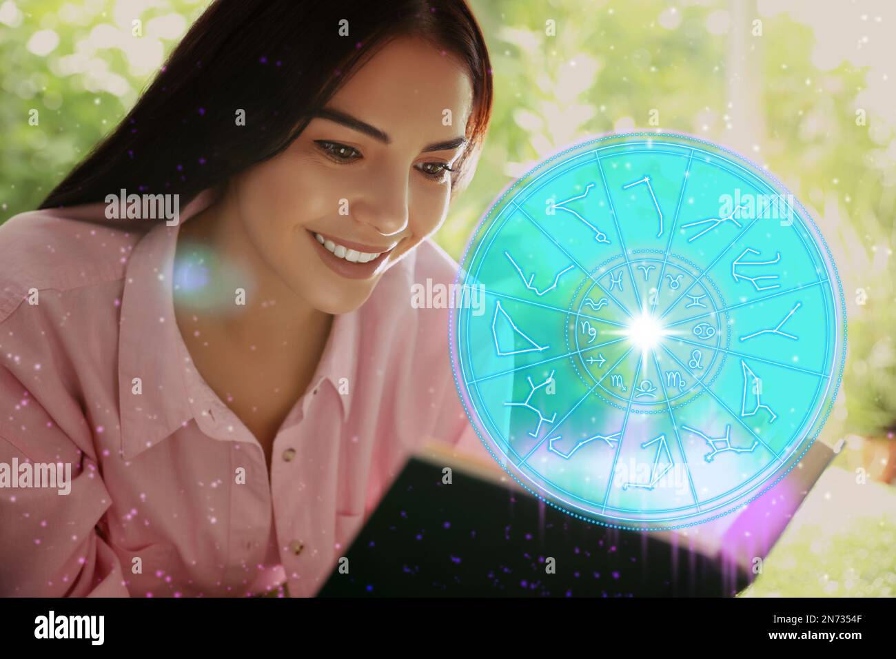 Young woman reading book outdoors and illustration of zodiac wheel with ...