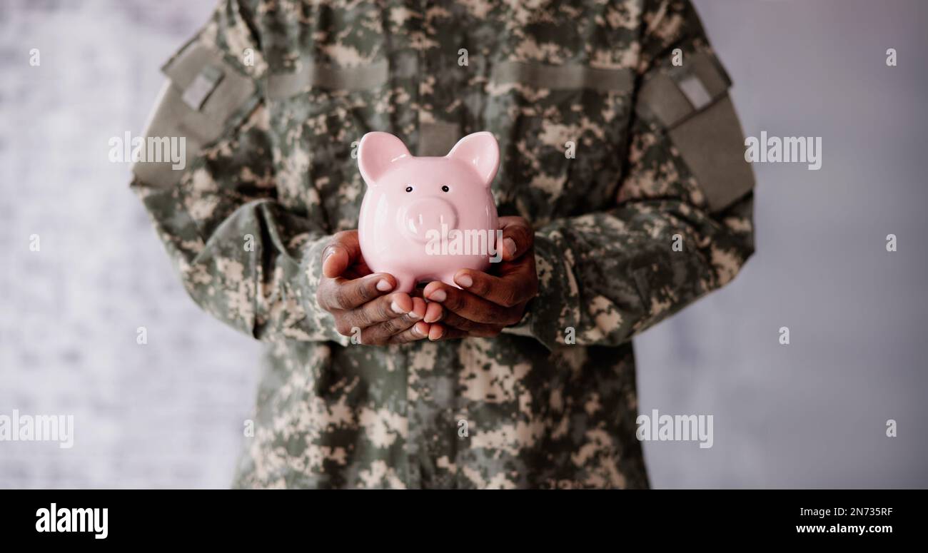 Soldier's Hand Holding Pink Piggy Bank. Save Income Stock Photo - Alamy