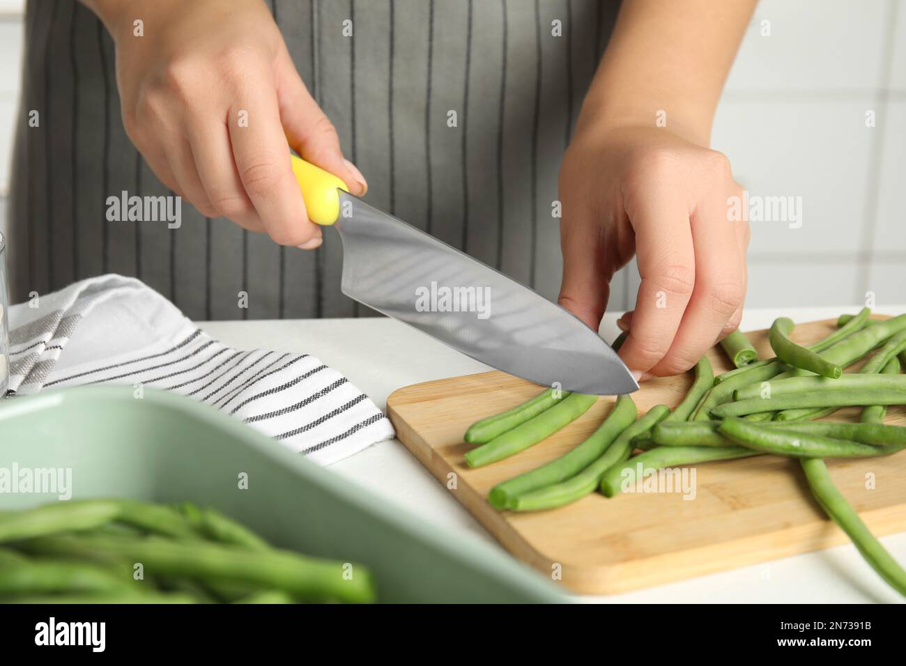 Woman cutting green beans at white table, closeup Stock Photo - Alamy