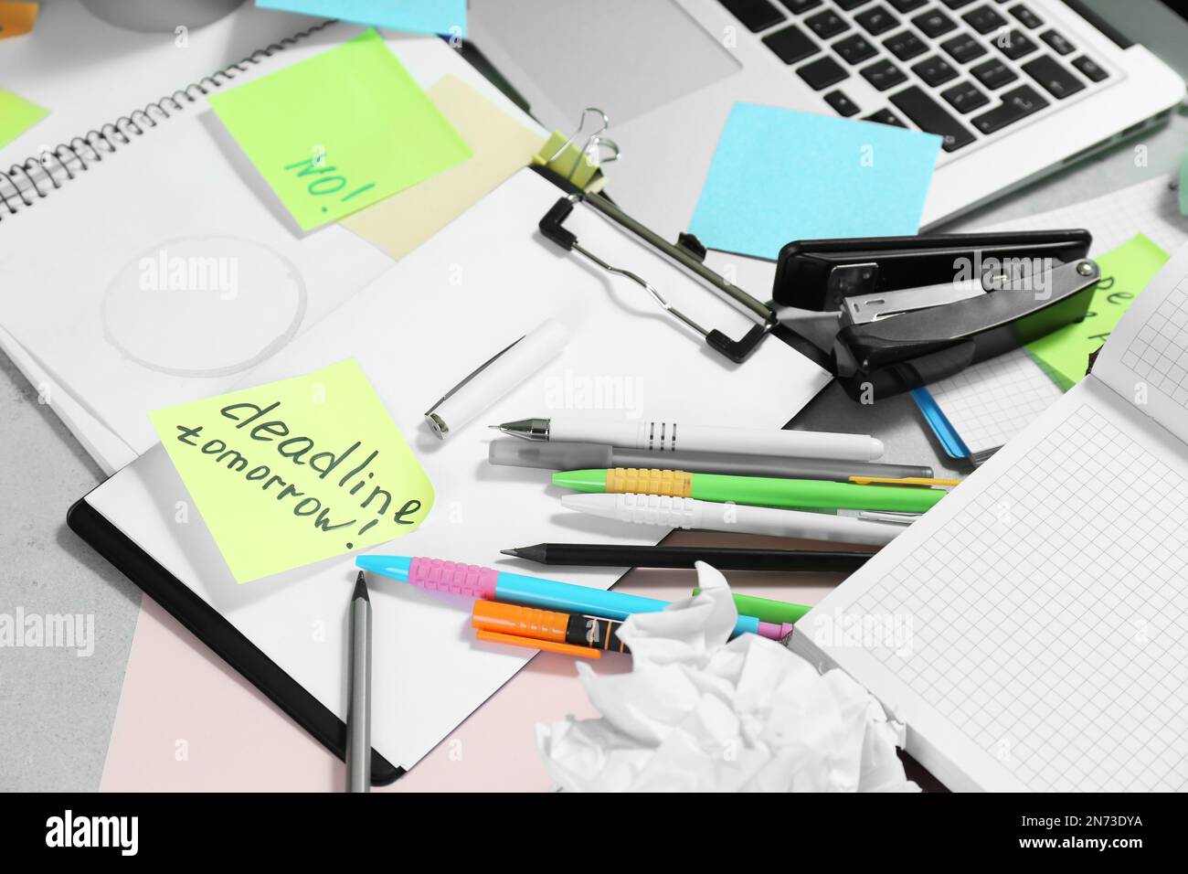 Messy table with laptop and stationery. Concept of being overwhelmed by ...