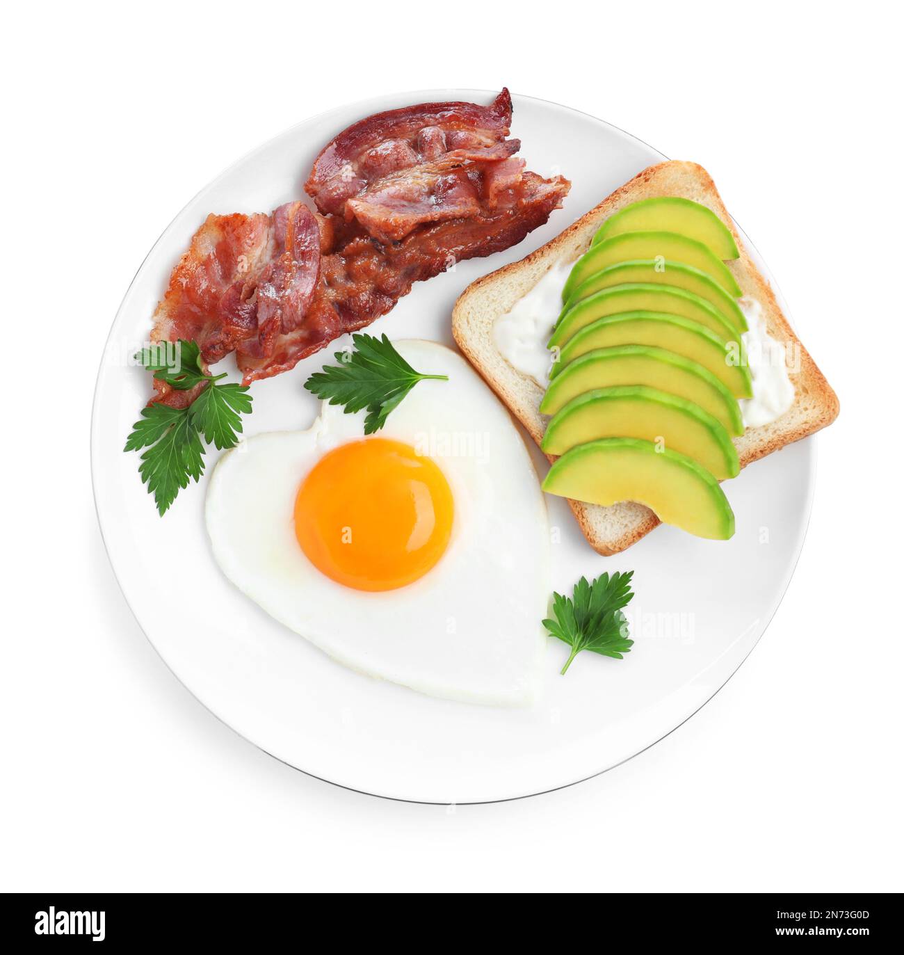 Romantic breakfast with fried bacon, heart shaped egg and avocado toast isolated on white, top ...