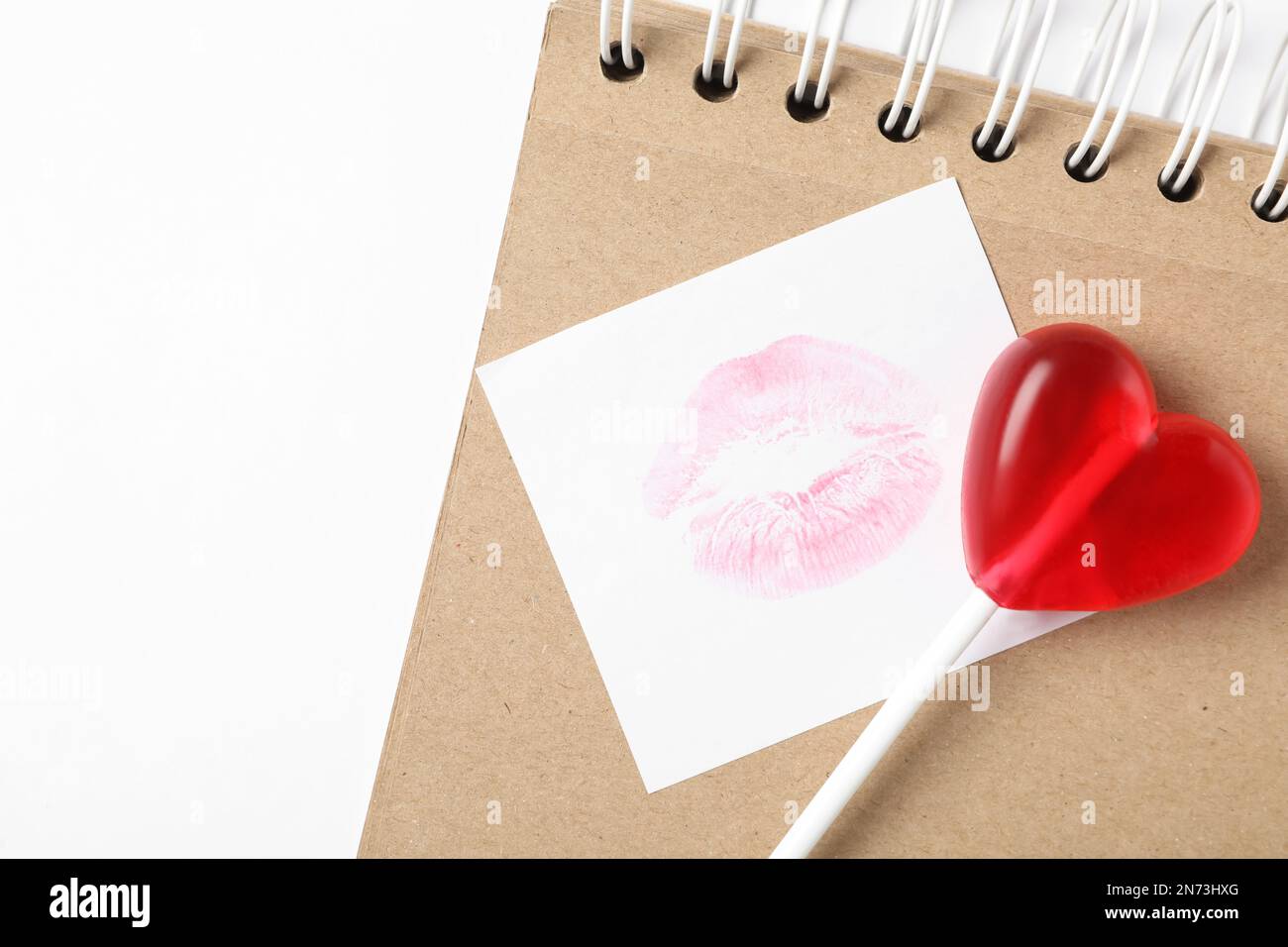 Heart shaped lollipop, notebook and paper note with lipstick kiss on ...