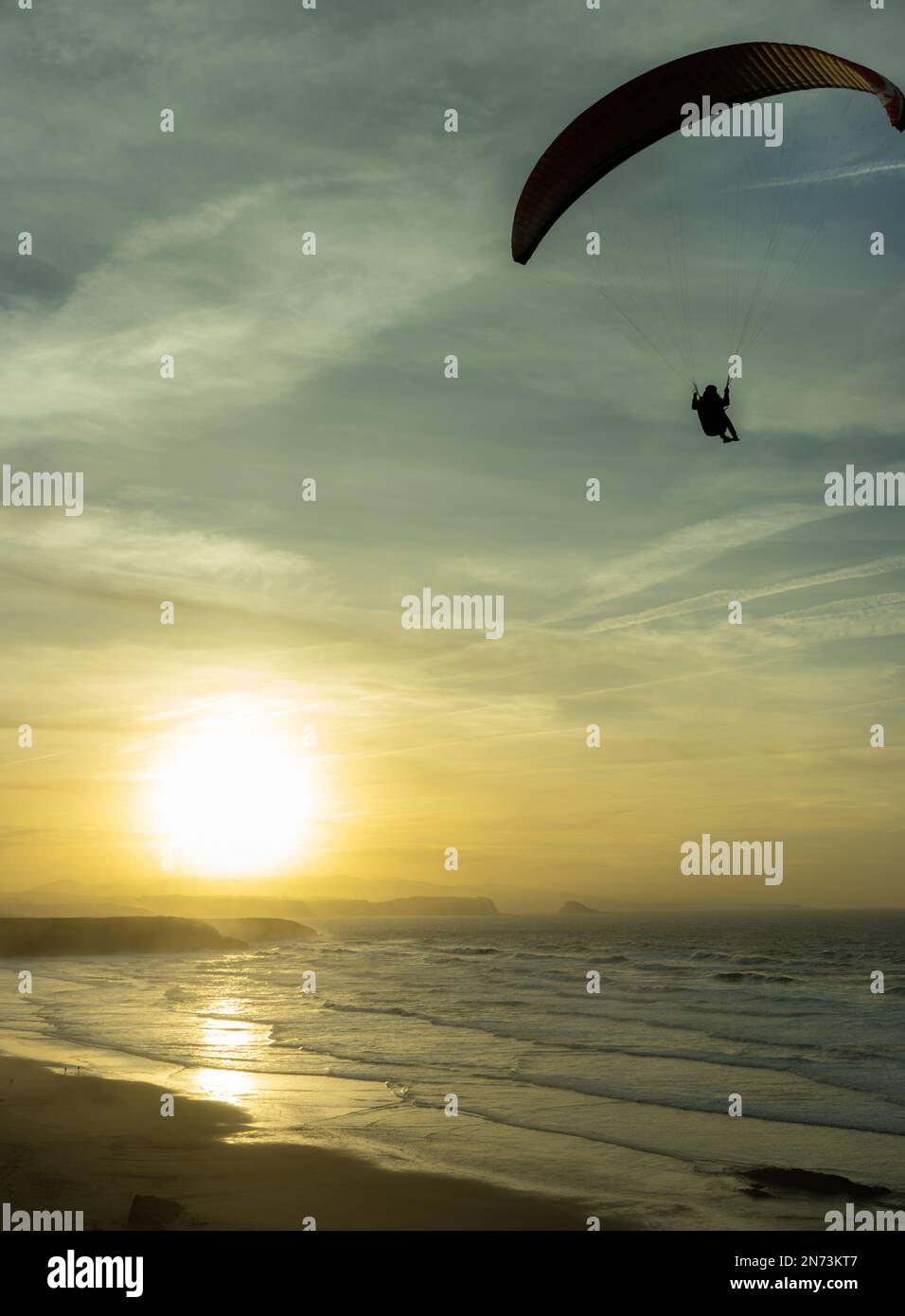 beautiful sunset on the beach with a man flying on a paraglider Stock ...