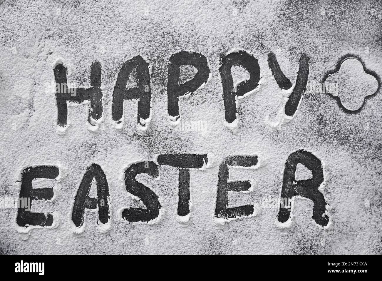 Words Happy Easter written in flour on black table, top view. Baking ...