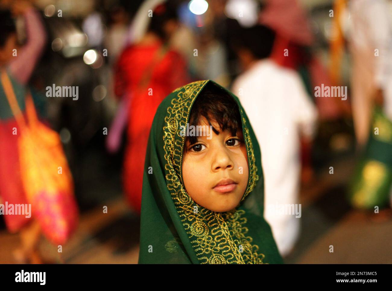 A Bahraini girl in traditional dress looks up in the western village of ...