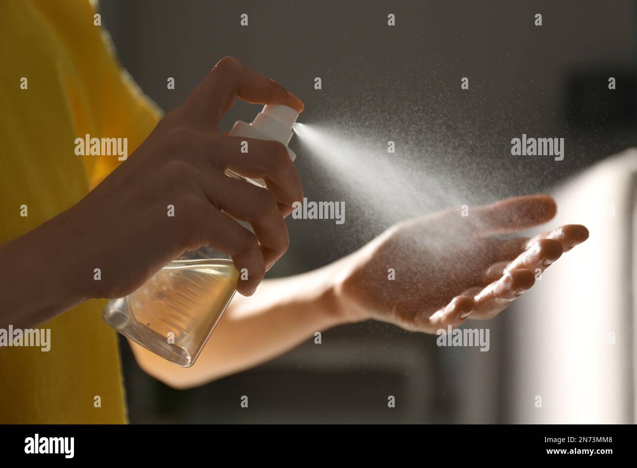 Little girl spraying antiseptic onto hand indoors, closeup Stock Photo ...