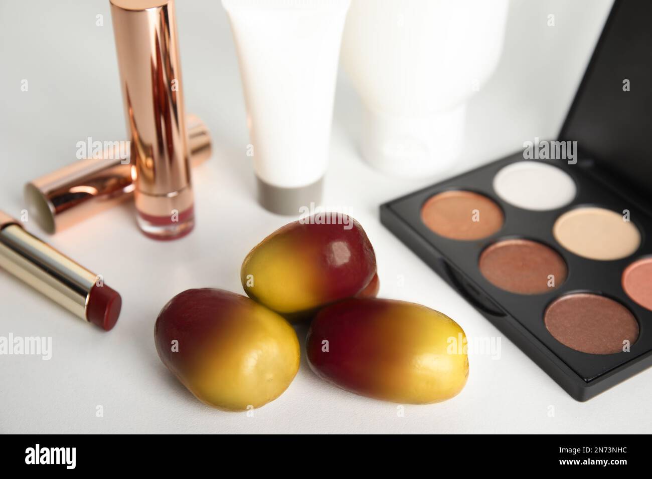 Fresh ripe palm oil fruits and cosmetic products on white background ...