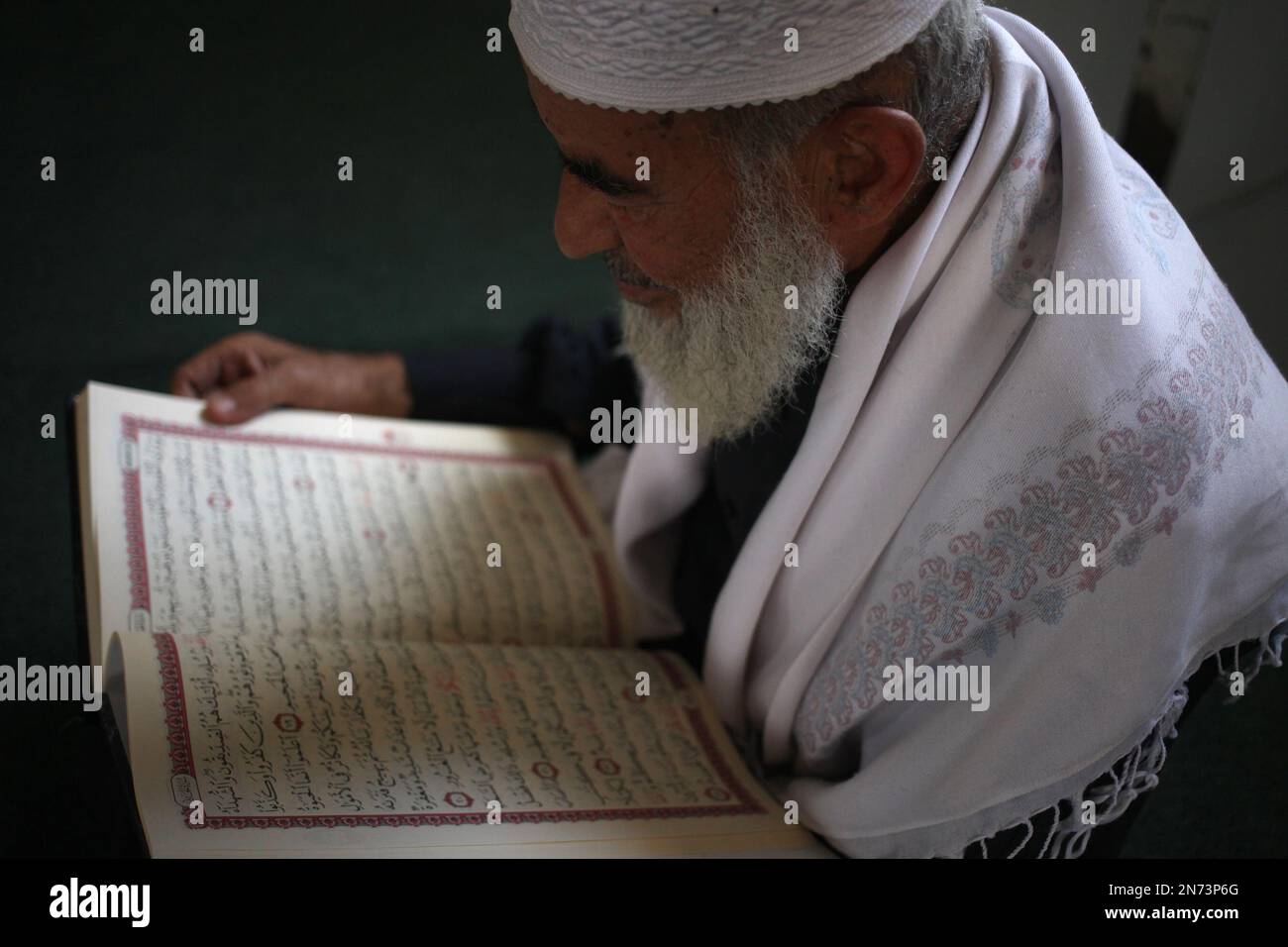 Sheik Mahmoud al Khateeb, 77, a Syrian refugee from Daraa, reads the ...