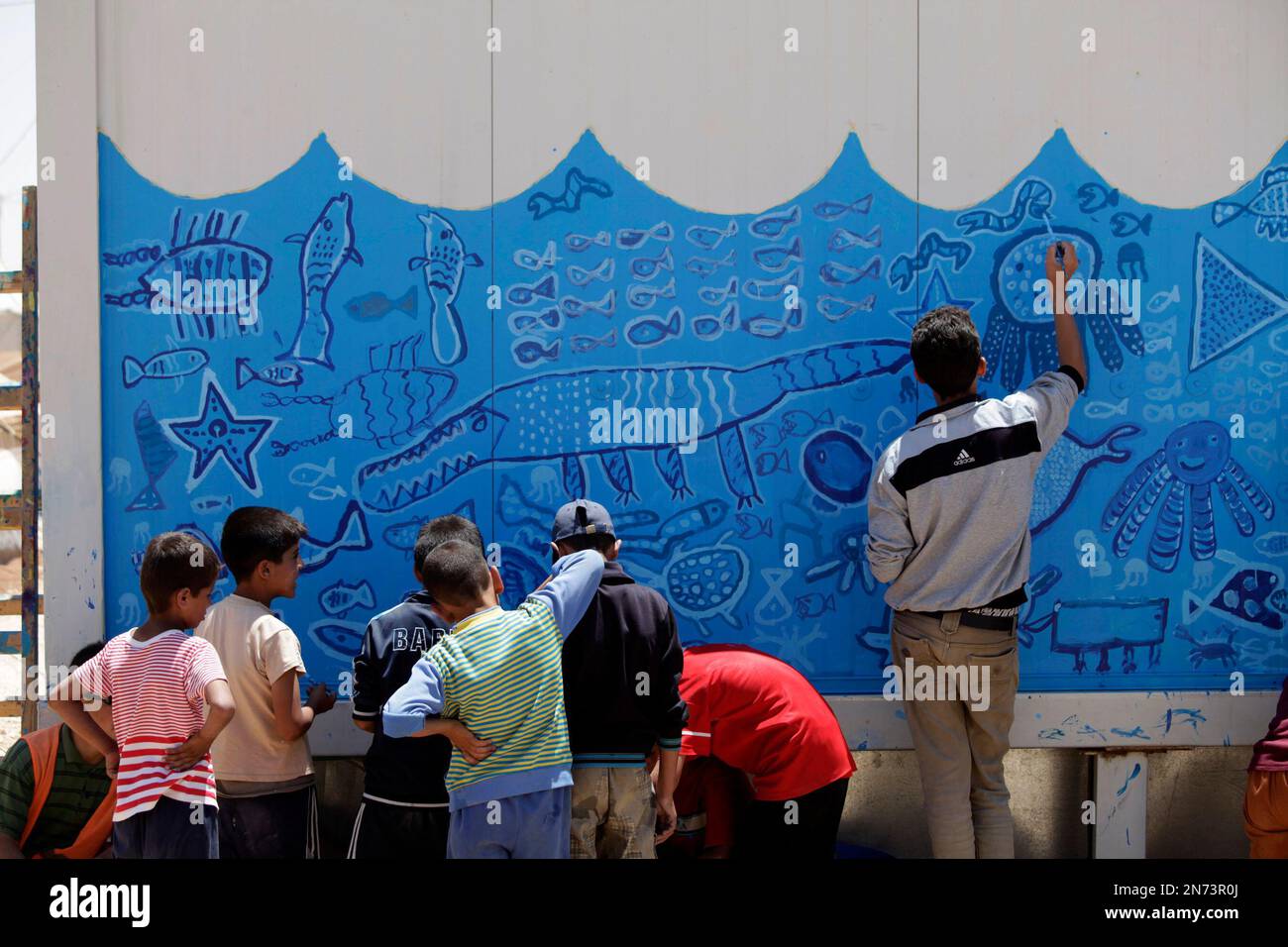 Syrian refugees paint a mural at Zaatari refugee camp, near the Syrian ...