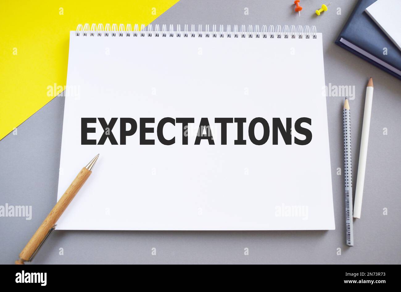 Expectations. Text written in Noebook on yellow gray background ...