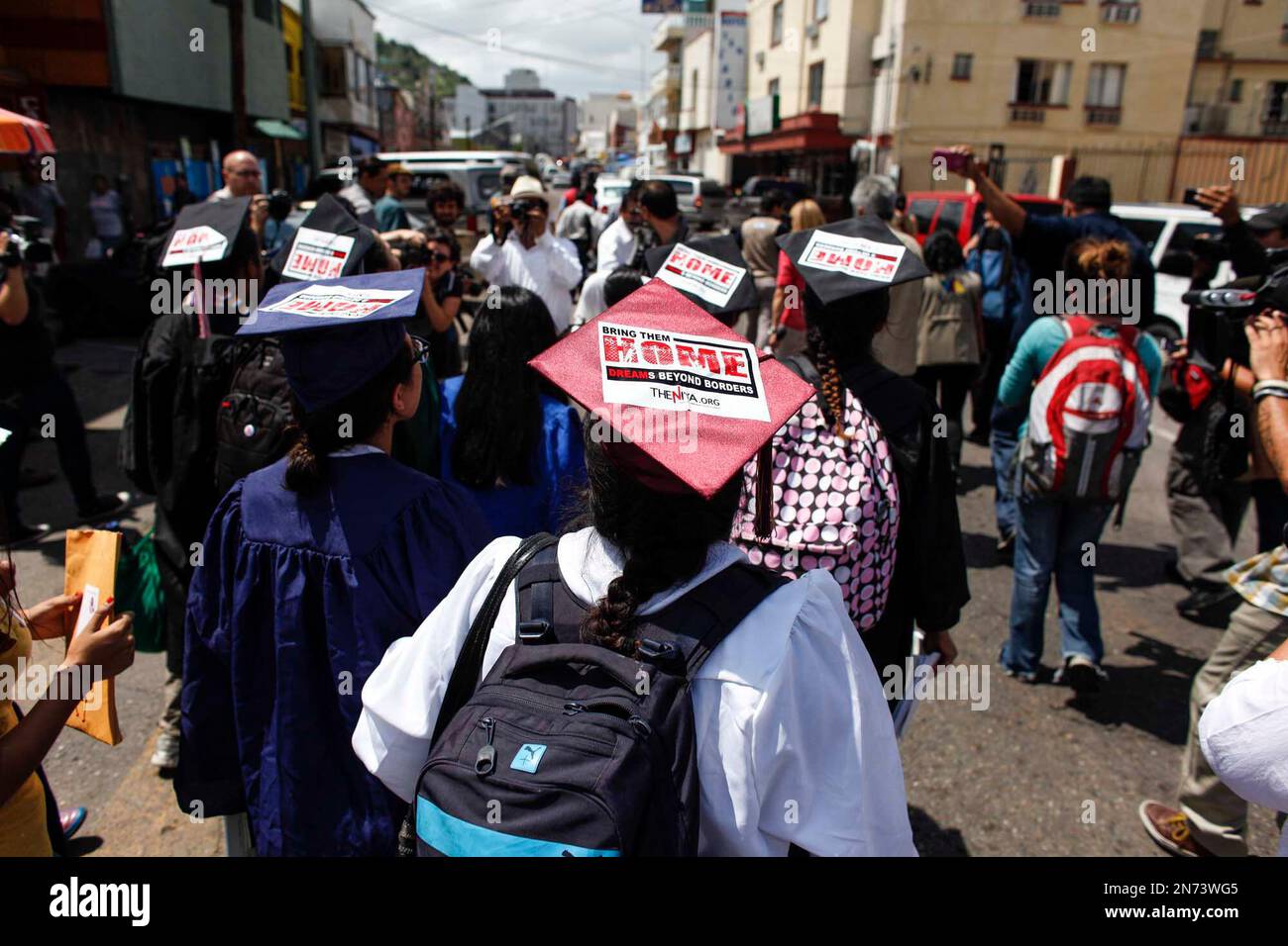 "Dreamers" wearing their school graduation caps and gowns to show their ...