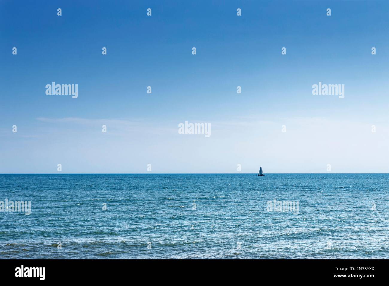 A distant sailboat on the Mediterranean Sea near the northern Italian ...
