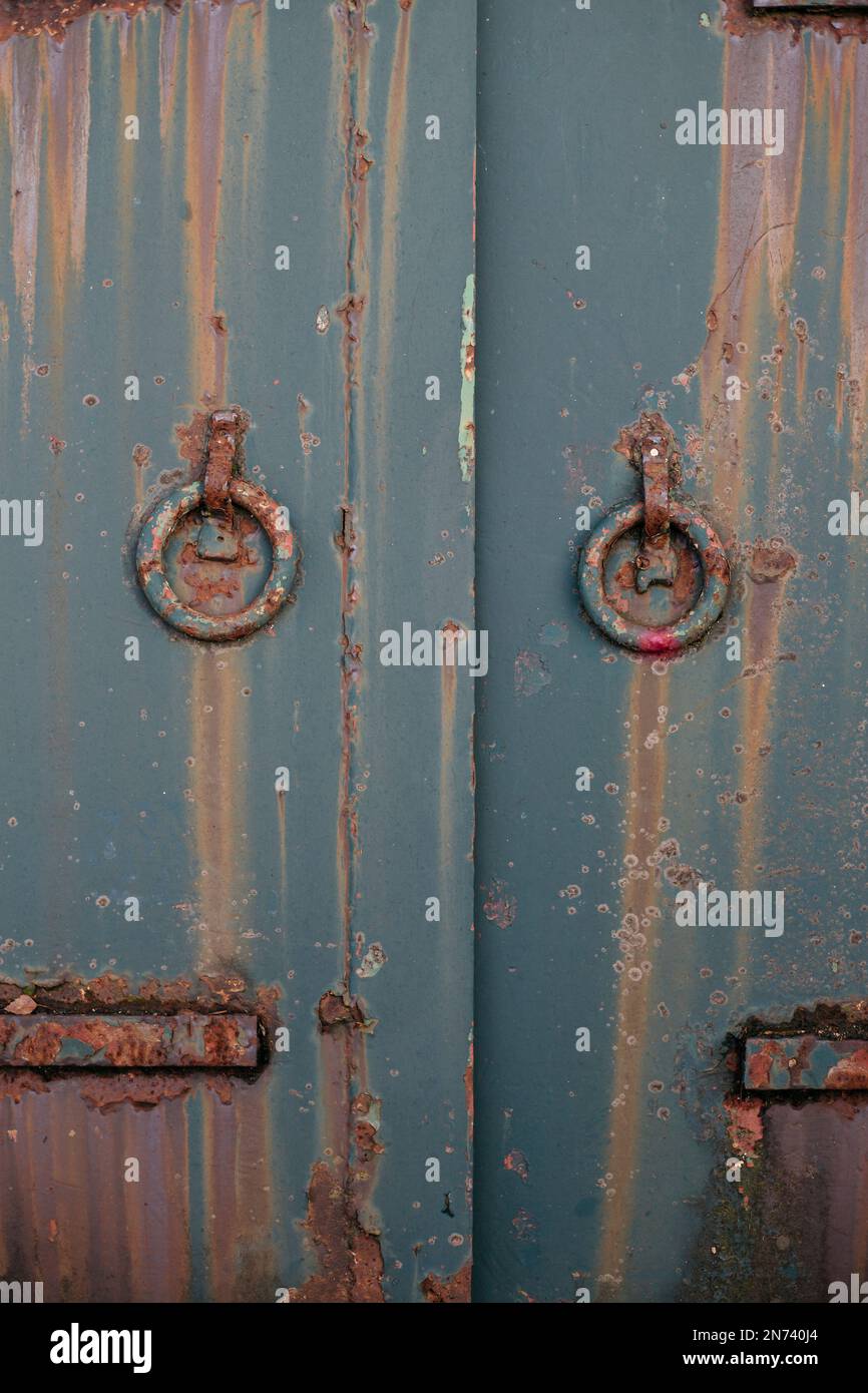 Rusty door with round handles Stock Photo - Alamy