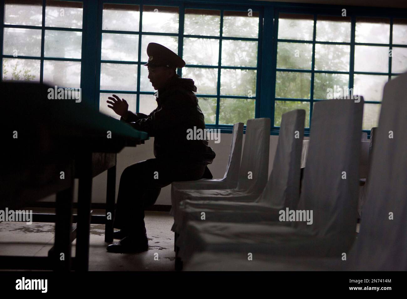 A North Korean soldier sits inside a room where the armistice agreement ...
