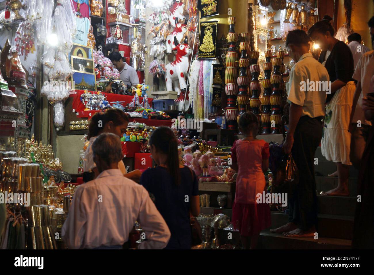 Buddhist devotees buy souvenirs as they visit Shwedagon Pagoda during ...