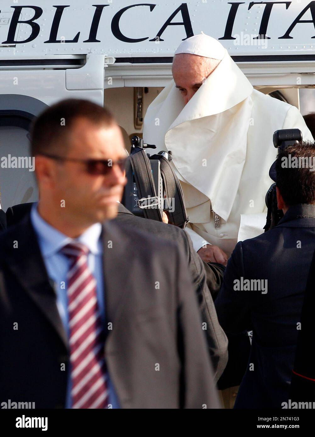 Wind blows over Pope Francis' cape as he disembarks from an Italian Air ...