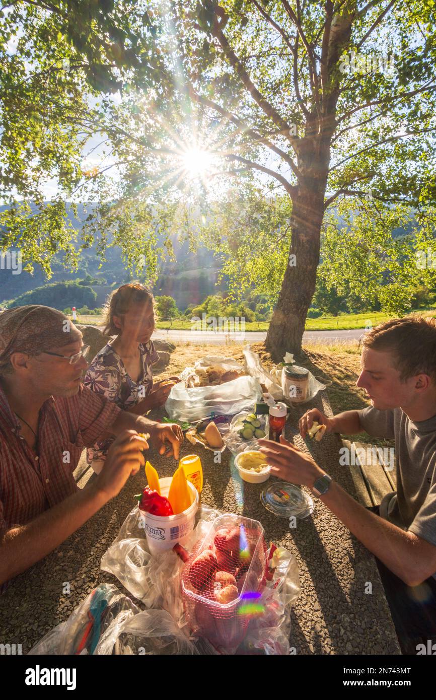 Family at pick nick table eating in alsace elsass hi-res stock ...