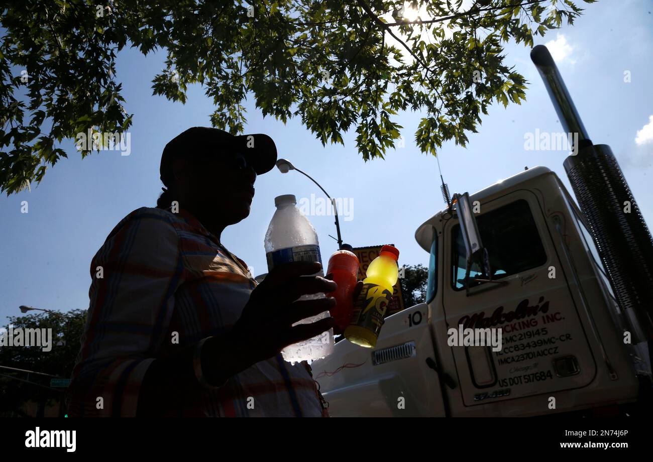 Michelle Dyer is silhouetted as she sells cold drinks along Ashland ...