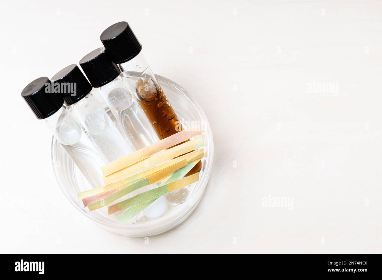 above view of several test tubes with liquids and solutions and litmus ...